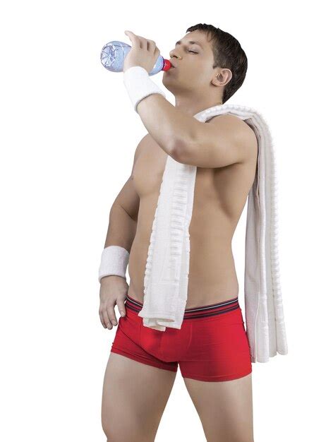 Atleta hombre desnudo con toalla de algodón blanco bebiendo agua de