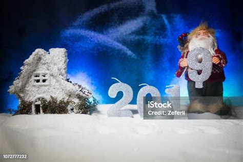전나무 나무는 밤에 눈에서 크리스마스와 새 해 미니어처 하우스 나무와 눈에 작은 장난감 집 축제 배경입니다 크리스마스 장식입니다