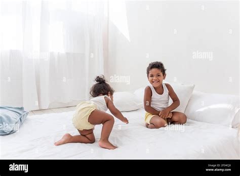 Frère Et Soeur Afro Américains Jouent Ensemble Sur Un Lit Blanc Dans Un