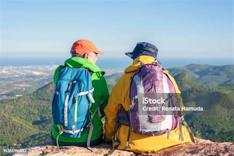 멋진 경치를 감상 할 수있는 산 꼭대기에 앉아있는 두 명의 친구 등산객 하이킹에 대한 스톡 사진 및 기타 이미지 하이킹