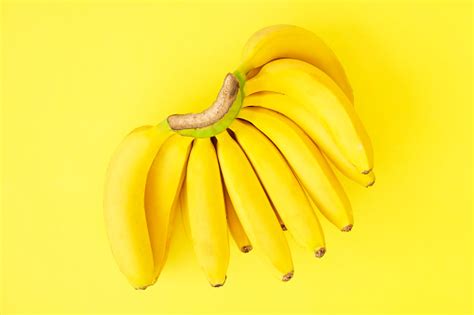 아름 다운 Minimlistic 플랫 누워 따뜻한 노란 색상 손잡고 익은 신선한 유기농 바나나와 구성 보기 복사 공간 탑 건강한