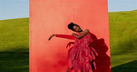 분홍색 드레스를 입은 여자가 빨간 조각상 앞에 서 있다 사진 Unsplash의 드레스 이미지