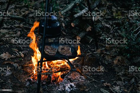 야외에서 화재 근처 팬 물 병 티타늄 머그잔에 캠프 파이어 쇠고기 부시 크래프트 모험 여행 관광 및 캠핑 개념 Entrecôte