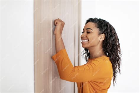 Premium Photo Happy African American Female Knocking At Door Indoors