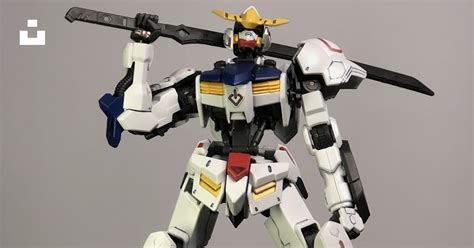 흰색 파란색 노란색 로봇이 검은 패널에 칼 장난감을 들고 있습니다 사진 Unsplash의 무료 세부 시티 이미지