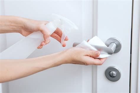 정무제 젖은 물티슈와 소독제 스프레이와 흰색 도어 핸들 청소 코로나 바이러스에 대한 병원과 공공 장소에서 소독 여자 손 사용