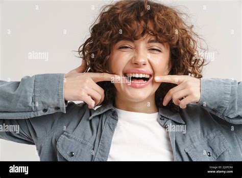 Ginger Joyful Woman Laughing And Pointing Fingers At Her Cheeks