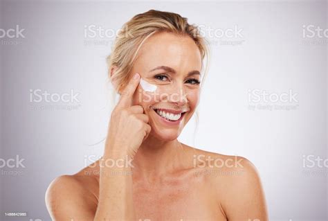 초상화 스킨케어 로션은 노화 방지 뷰티 트리트먼트를 위해 회색 배경에 스튜디오에서 성숙한 여성과 함께한다 얼굴 제품 및 크림은 모이스처 라이저를 적용하기 위해 욕실에서