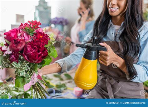 Smiling African American Florist Watering Bouquet Of Beautiful Flowers Stock Photo Image Of