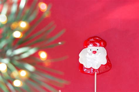 롤리팝 산타 클로스 캐러멜과 보케 효과와 흐릿한 소나무 가지와 레드 크리에이티브 추상 커버 디자인 엽서 게시물 및 프로모션을 위한 템플릿입니다 공간을 복사합니다 플랫 레이