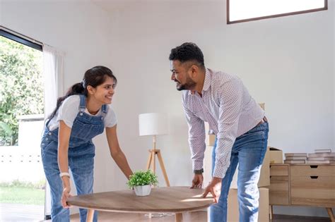 Premium Photo A Couple Moves Into A New House Happily Holding Boxes