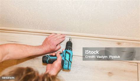 사람이 드릴베이스 보드를 설치하고 있습니다 수리는 실내에서 작동합니다 아파트에서 개조 개선에 대한 스톡 사진 및 기타 이미지 개선 건축물 굽도리 널 Istock