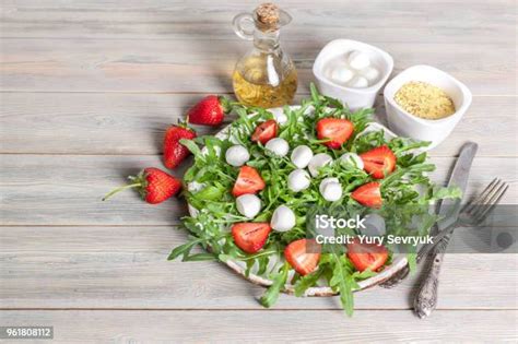 맛 있는 Rucola 샐러드와 모 짜 렐 라 딸기 올리브 기름 향미료 나무 배경에 건강 식품 건강한 식생활에 대한 스톡 사진 및