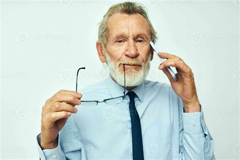 Photo Of Retired Old Man In A Shirt With A Tie With A Phone Technology