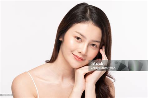 美しいアジアの若い女性は清潔で新鮮な肌の幸せと肯定的な感情的で陽気な笑顔を持つ美しいアジアの若い女性灰色の背景に隔離美容と化粧品のコンセプト