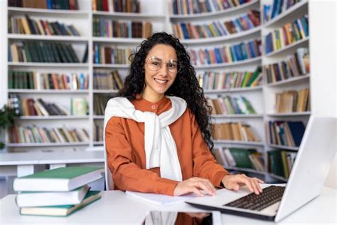 Retrato de una alegre estudiante sonriente mirando a la cámara sentada