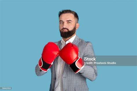 블루 스튜디오 배경에서 싸울 준비가 권투 장갑에 심각한 밀레니엄 사업가 경영자에 대한 스톡 사진 및 기타 이미지 경영자