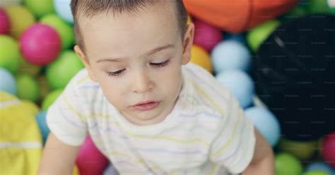 놀이터에서 어린 소년입니다 백인 어린 소년은 색깔 있는 공에 앉아 있다 사진 Unsplash의 거실 이미지