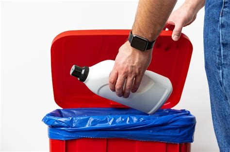 Premium Photo A Man Throws Garbage Into The Trash Can Close Up