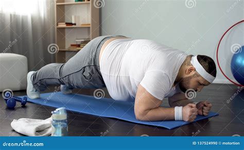 Fat Man Practicing Plank Exercise On Mat During Home Workout Will