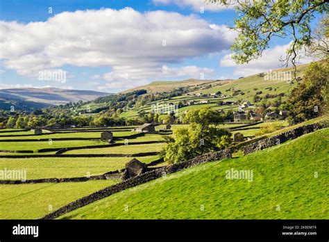 View To Village Across Countryside With Barns And Drystone Walls In