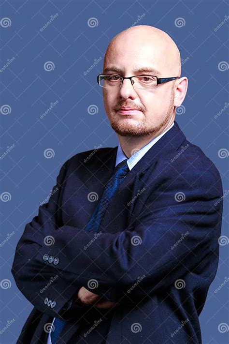 Bold Headed Guy With Glasses Looking Into The Camera Wearing Jacket