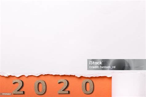 흰색 판지의 찢어진 스트립에서 나무 그림 2020 날짜 찢어진 종이의 오렌지 구멍에 숫자 새해 개념 달력 커버 디자인 0명에