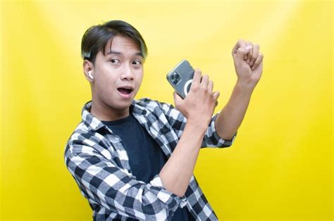 Premium Photo A Cheerful Asian Man With Peek A Boo Hair Uses Airpods
