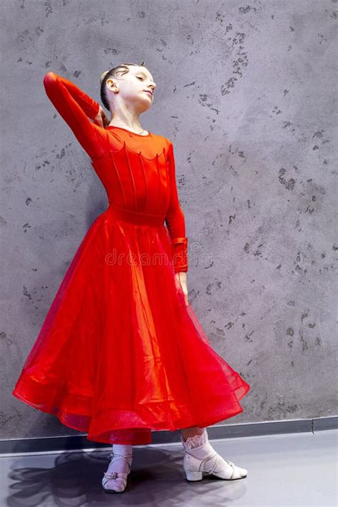 Happy Girl Dancing In A Bright Red Dance Dress On A Gray Background