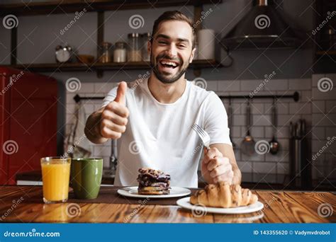 Portrait Of Joyful Man 30s Eating While Having Breakfast In Stylish