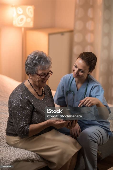 디지털 태블릿을 사용 하 여 고위 여자를 돕는 젊은 간호사 노인에 대한 스톡 사진 및 기타 이미지 노인 태블릿 말하기 Istock