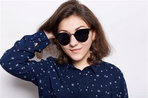 사람과 생활 개념입니다 유행 여자 라운드 Hipster 선글라스와 세련 된 셔츠는 카메라 보고 웃 고 머리에 그녀의 손을 잡고의
