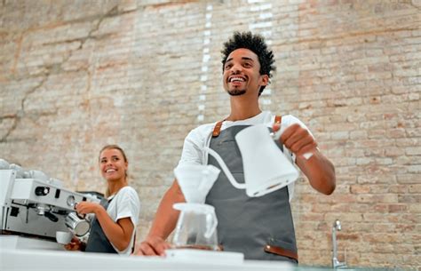 Premium Photo Beautiful Caucasian Female Barista Prepares Coffee And Attractive African Male