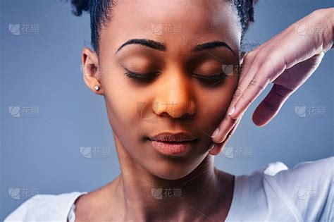 一个年轻黑人妇女抚摸她脸颊的性感肖像