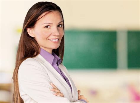 Premium Photo Smiling Teacher Standing In Front Of Blackboard