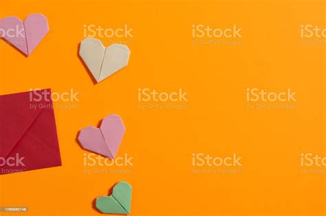 노란 배경에 사랑에 빠진 커플을 위한 발렌타인 데이를 축하하기 위해 컬러 종이로 만든 종이 접기 하트 2월에 대한 스톡 사진 및