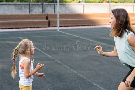 Mom And Daughter Have Fun On The Outdoor Sports Ground A Caucasian