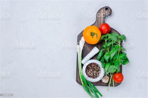 잘 익은 빨간색과 노란색 토마토 파와 바질 마늘 소금과 밝은 회색 돌 배경에 향신료 맨 위 보기 공간 복사 건강한 식생활에 대한