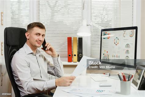 웃는 비즈니스 남자 셔츠는 책상에 앉아 즐거운 대화 현대 모니터 문서 창 배경에 빛 사무실에 있는 컴퓨터에서 작업을 실시 휴대