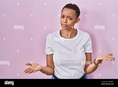 Beautiful African American Woman Standing Over Pink Background Clueless