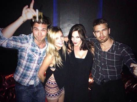 Four People Posing For The Camera At A Party