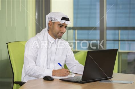 رجل اعمال عربي سعودي خليجي يعمل في مقر الشركة ، التدوين ومراجعة