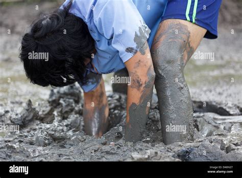 Young Man Digging Mud For Planting New Tree For Mangrove Reforestation