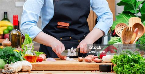 셰프는 나무 테이블 주방용품 야채 허브 및 요리 재료가 있는 아늑한 주방에서 샬롯 양파를 자릅니다 건강한 비건 음식 요리 조리법 블로깅 가정 생활에 대한 스톡 사진 및 기타