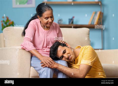 Indian Senior Mothers Talking To Adult Son By Consoling While Son Sleeping On Mothers Lap At