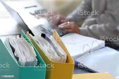 여자 손은 전경에서 종이로 채워진 바인더와 노트북 컴퓨터에 입력 합니다 선택적 초점 가정 생활에 대한 스톡 사진 및 기타 이미지