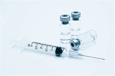 백색 배경에 단리된 바늘을 가진 약 또는 백신 및 3 Ml 플라스틱 주사기의 유리병 파란 색조 색깔 감기와 독감에 대한 스톡