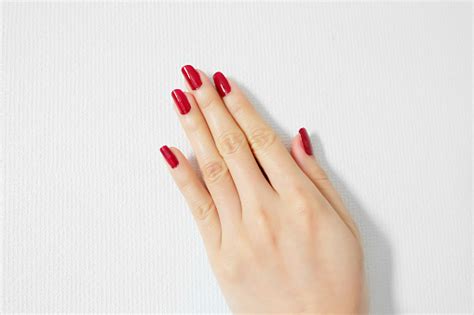 아름 다운 여자 빨간 손톱입니다 흰색 벽 배경에 고립 된 빨간 손톱 매니큐어와 여성 손 어떤 사용에 대 한 좋은 건강한 생활