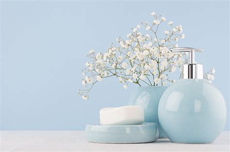 드레싱 테이블우아한 모든 부드러운 파스텔 블루 세라믹 그릇 흰 꽃 피부 및 바디 제품을 화이트 보드 나무와 푸른 벽 근접 촬영