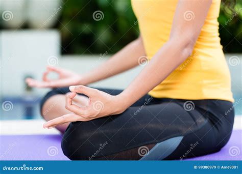 Young Woman Practicing Yoga In Lotus Position Outdoors Stock Image